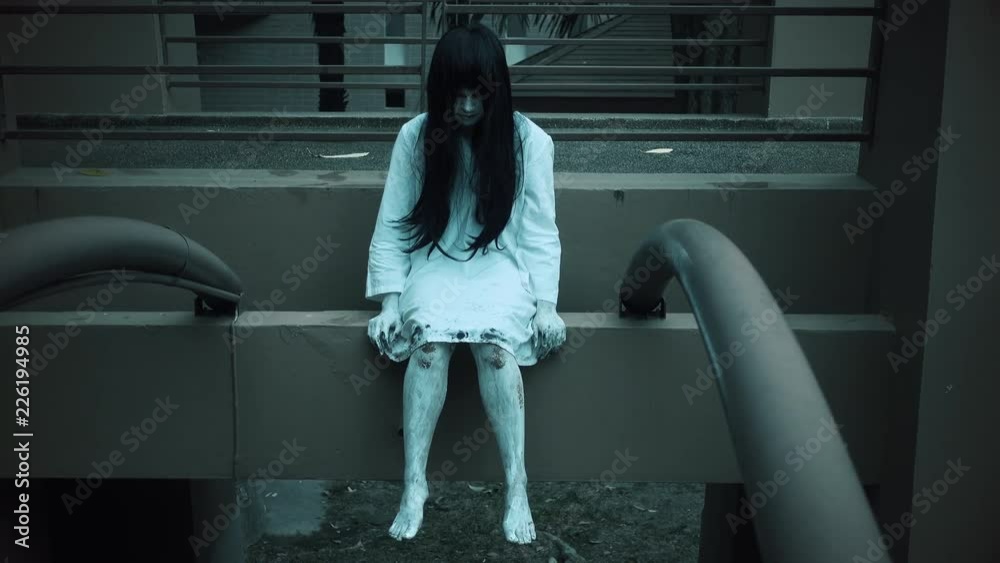 Woman horror scary ghost sitting hanging legs on building, halloween ...