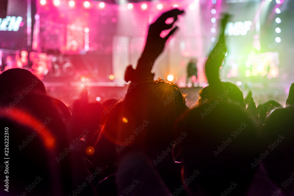 Crowd of hands up concert stage lights enjoying concert, and people fan ...