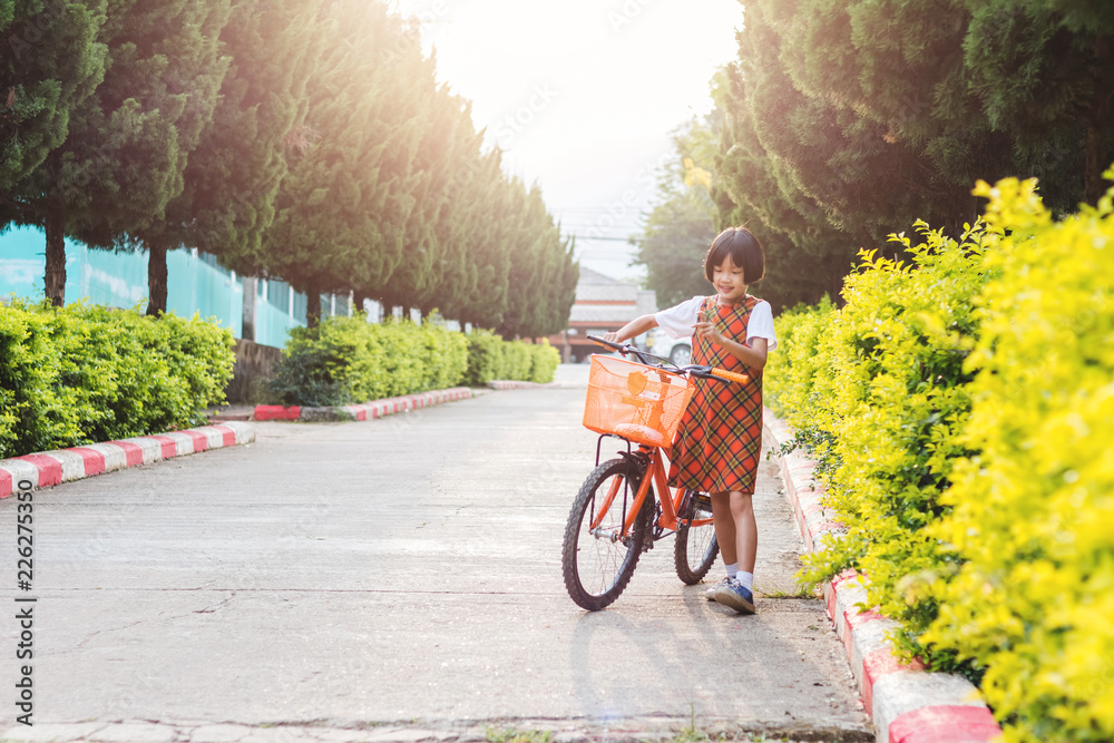 cute little girl riding bike in park Stock Photo | Adobe Stock