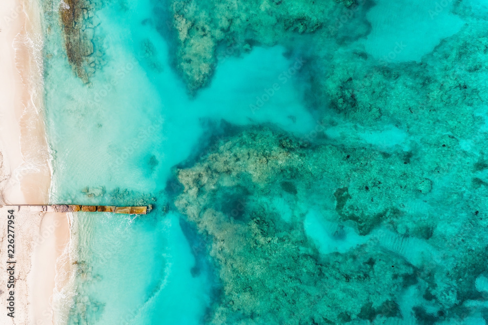 Beach with pier aerial top view. Caribbean ocean water, coral reefs ...