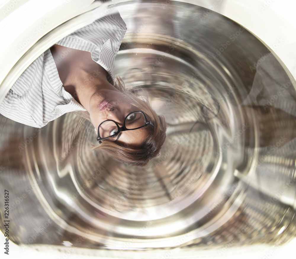 Confused businesswoman has dizziness inside a washing machine. Concept ...