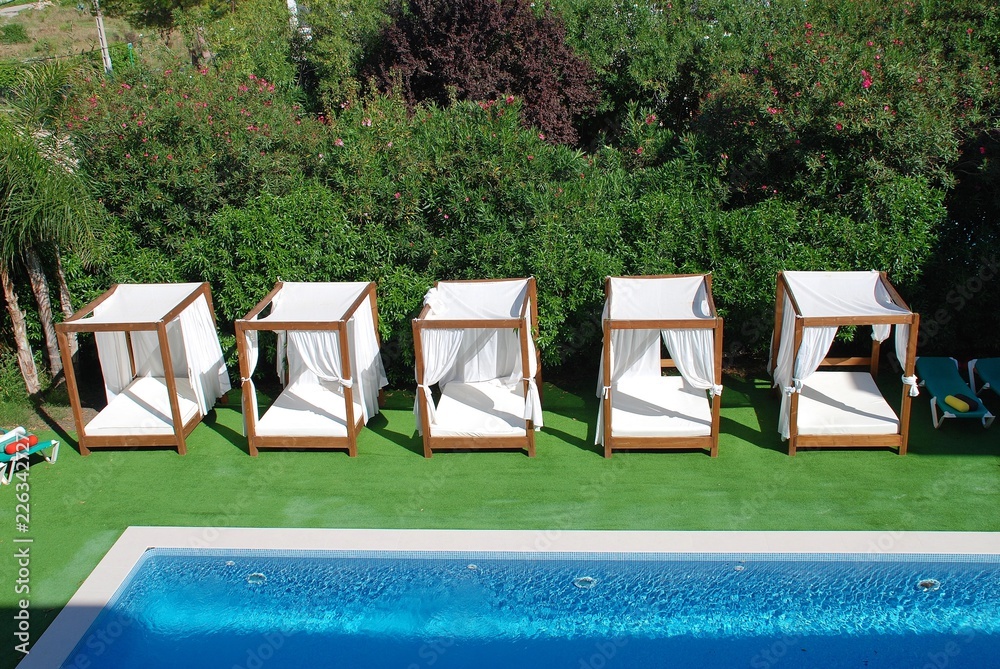 Four poster sunbeds by a swimming pool in Puerto Pollensa on the ...