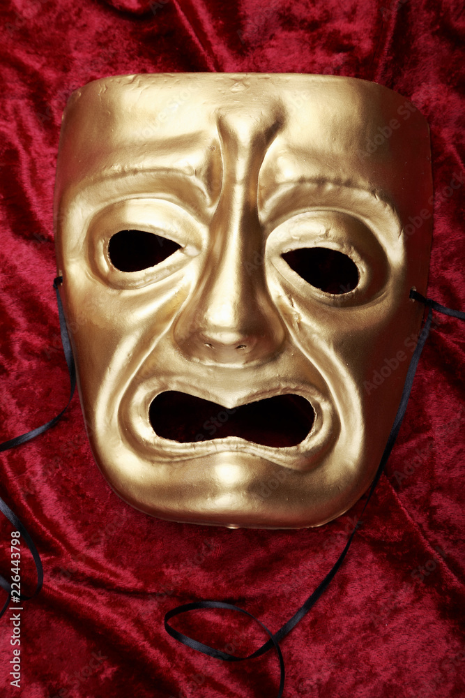 Tragedy mask on red velvet fabric Stock Photo | Adobe Stock