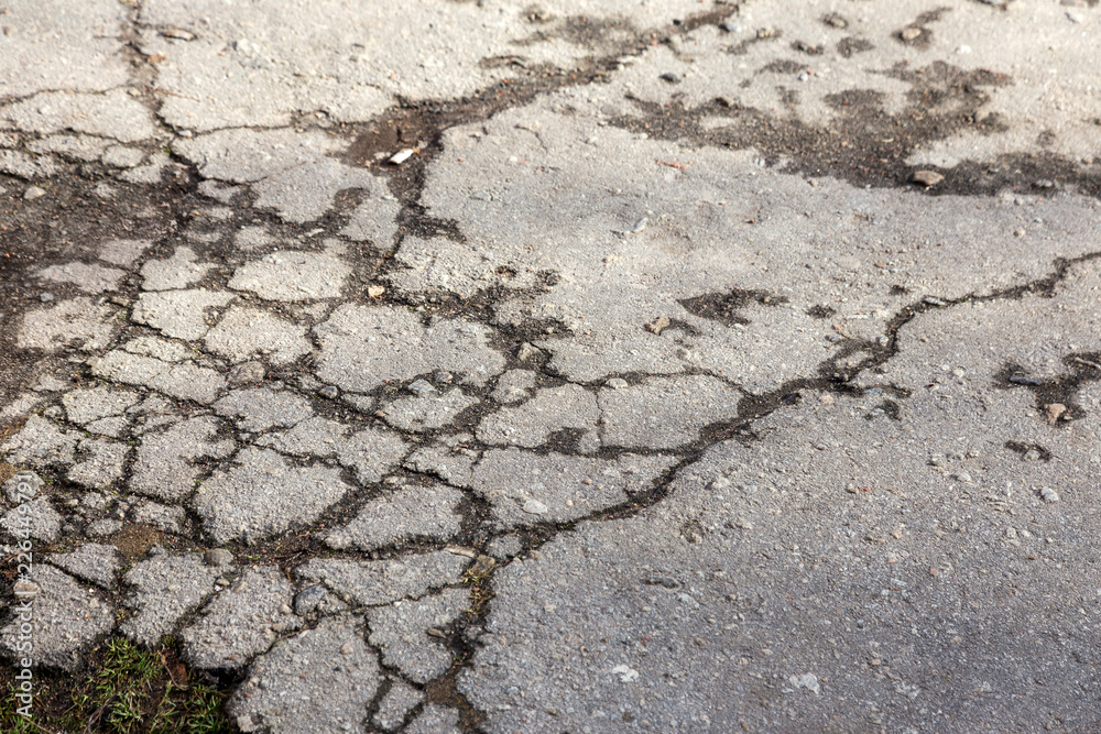 Damaged asphalt road with potholes, caused by freeze-thaw cycles in ...