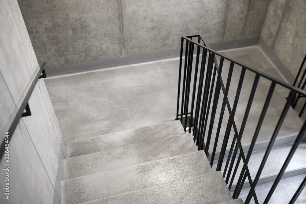 Modern elegant minimalist concrete staircase with black steel railings ...