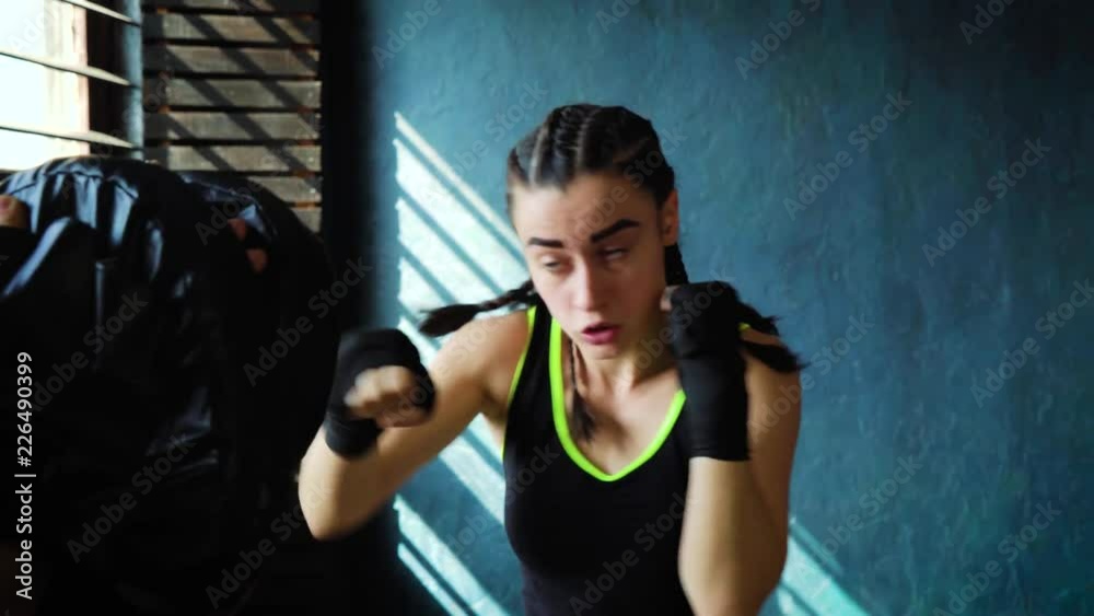 closeup fit white female boxer training with boxing coach at gym. Young ...