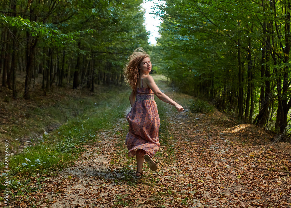 Scared girl running through forest Stock Photo | Adobe Stock