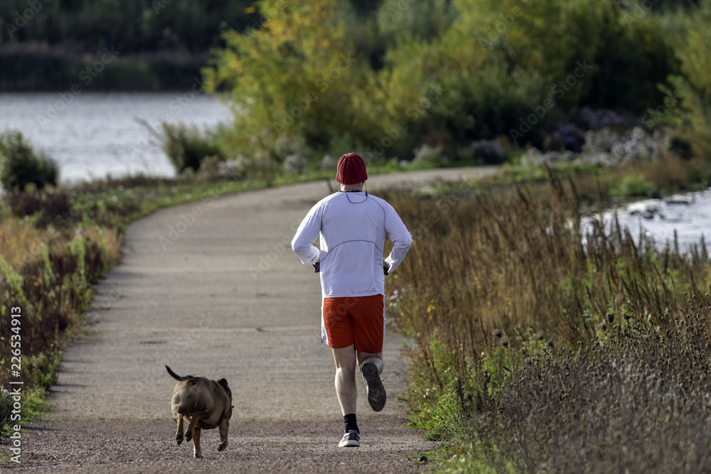 man running with his dog Stock Photo | Adobe Stock