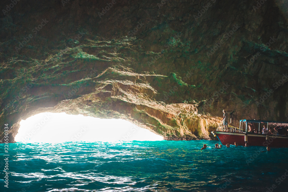 boat with group of tourists in beautiful grotto with azure transparent ...