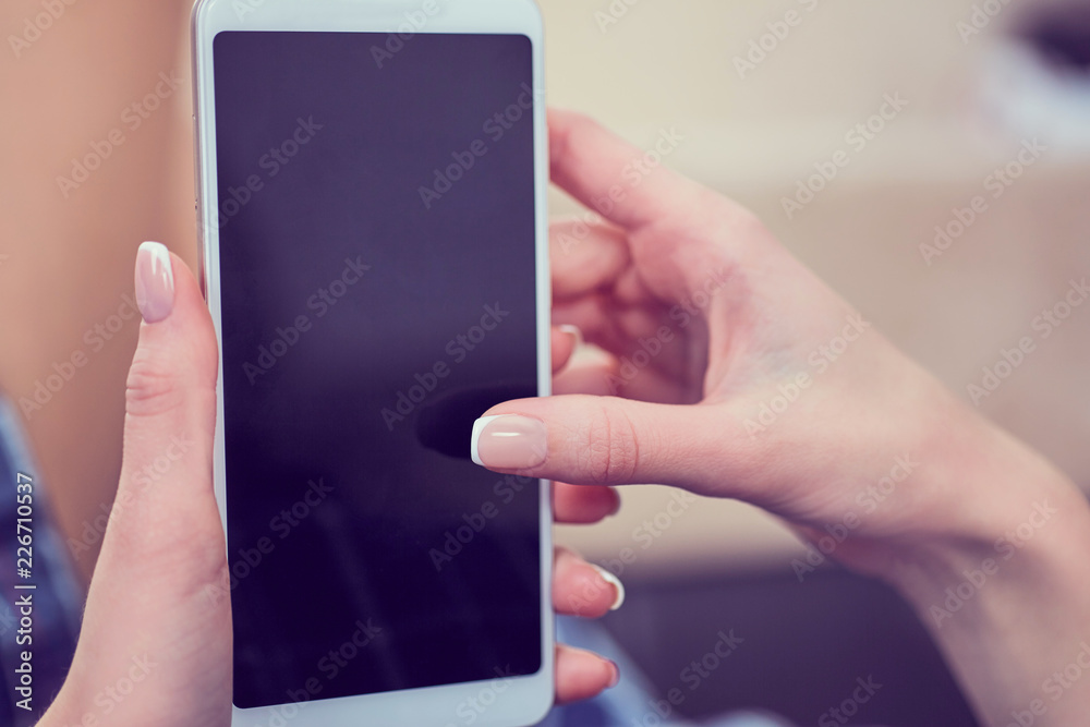 Back view of a woman hands using smart phone with blank screen close up ...
