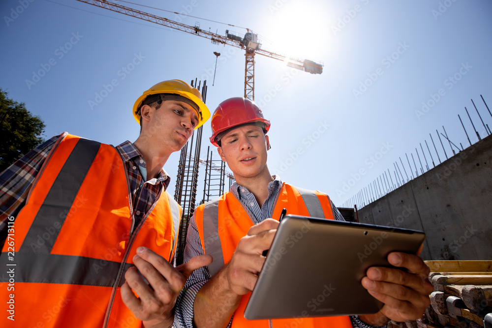 Architect and structural engineer dressed in orange work vests and ...