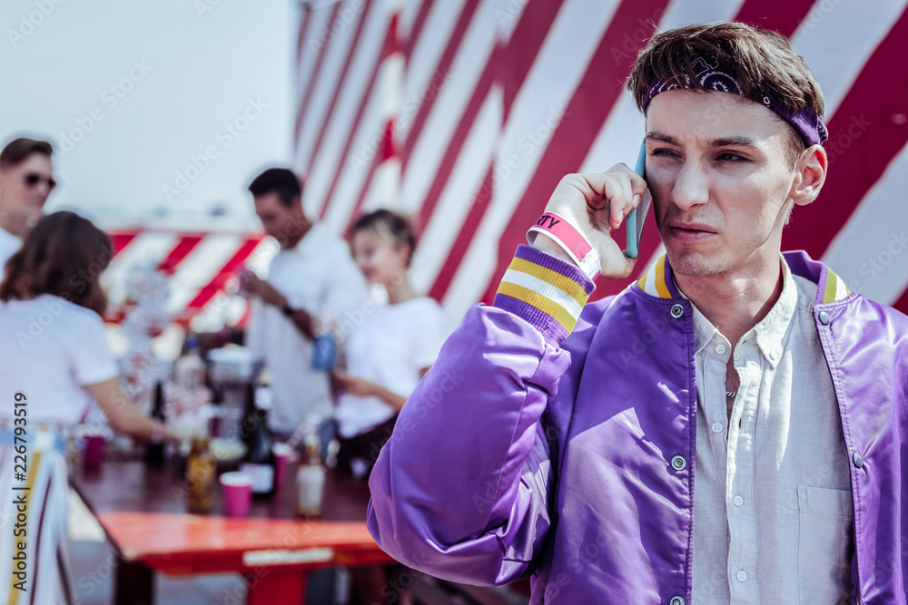 Suspicious glance. Concentrated brunette male using telephone while ...
