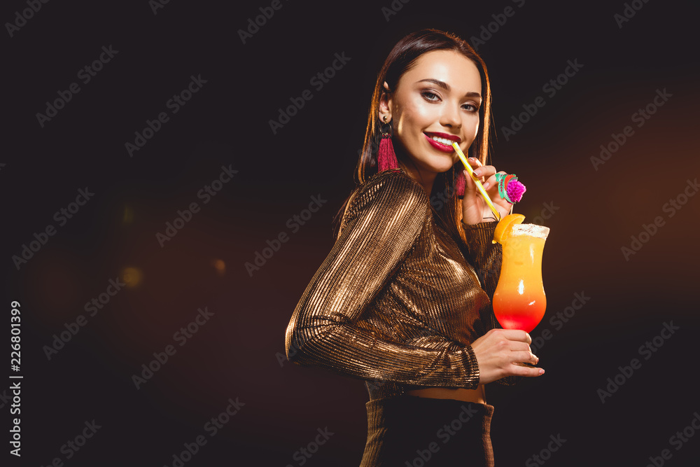 Foto de beautiful glamorous girl drinking alcohol cocktail on black do ...