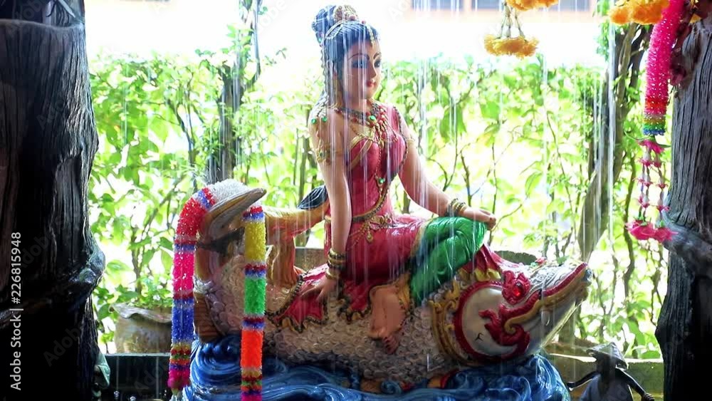 Phra Mae Thorani, goddess from Buddhist mythology, behind water of ...