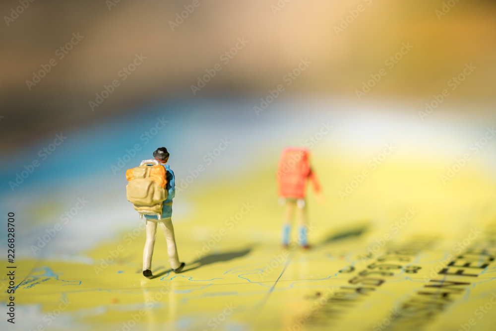 Travel Concept. Two traveler miniature figures with backpack walking on ...