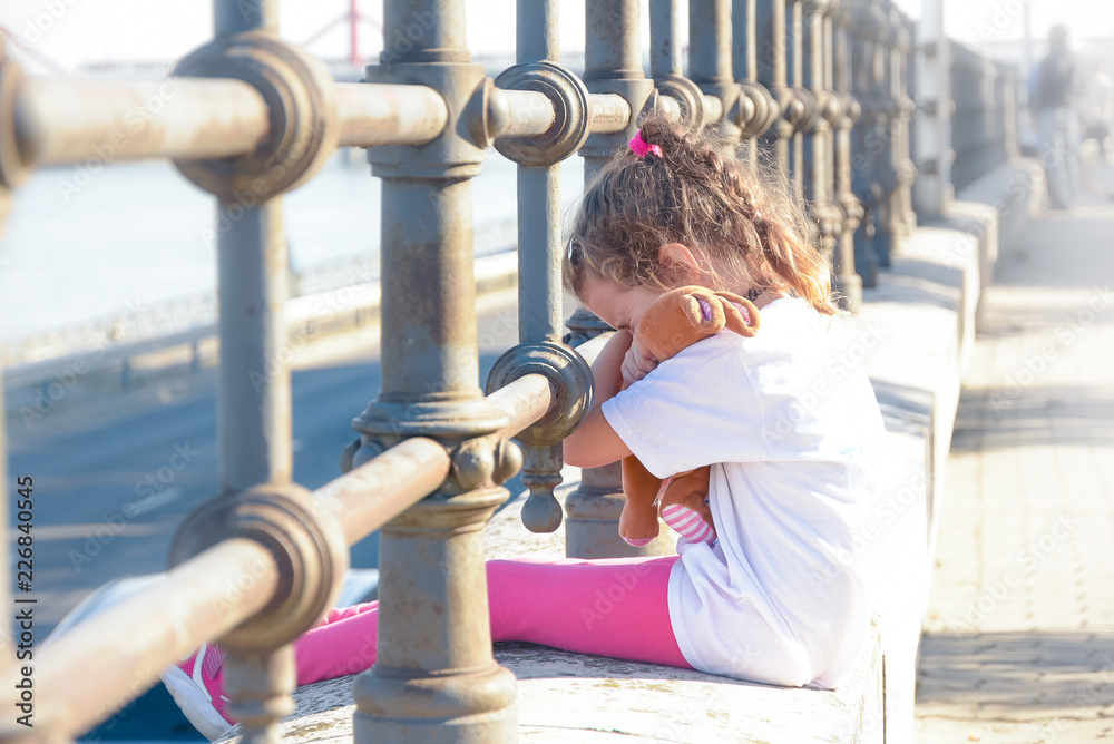 Sad child girl sitting with her plush toy Stock Photo | Adobe Stock