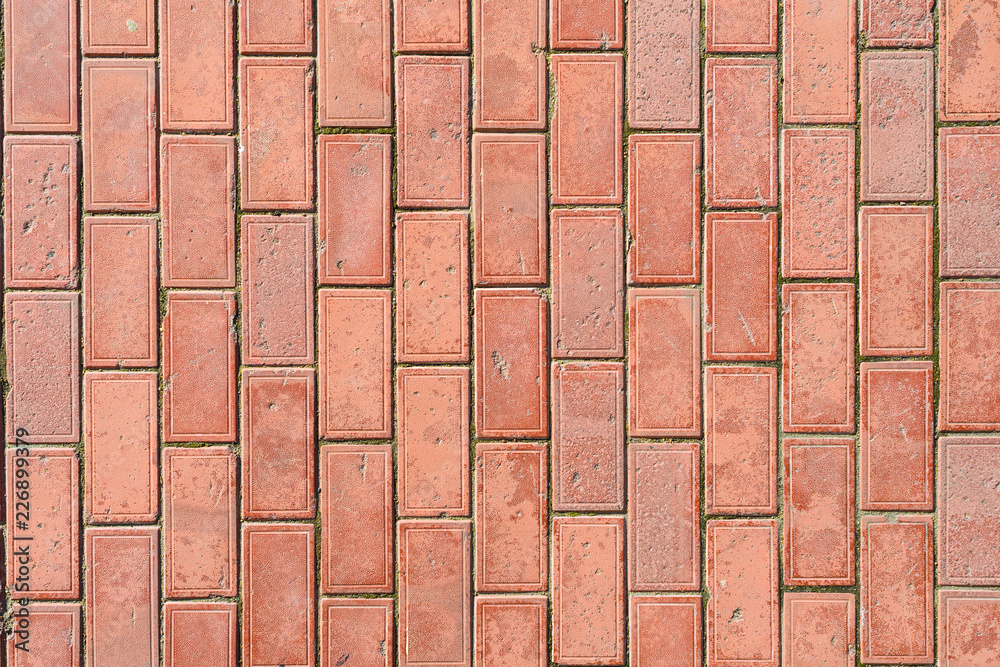 Red paving with imprinted texture of beaten time, with a lot of chips ...