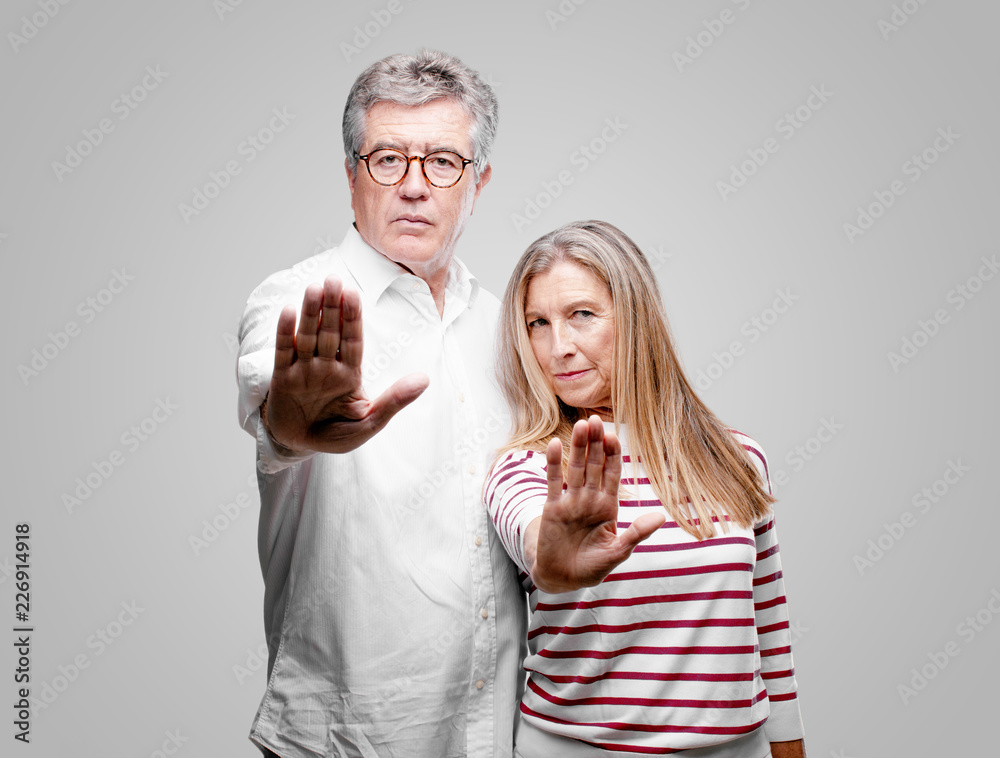 senior cool husband and wife Signaling stop with the palm of hand ...