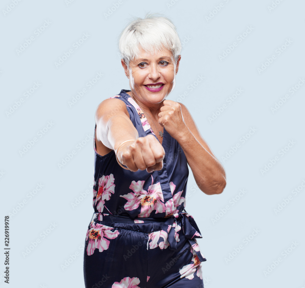 senior cool woman with an angry, aggressive and menacing pose, ready ...