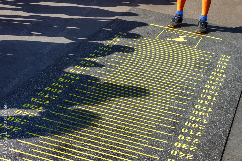 Legs of the boy preparing to standing long jump competition and shadows ...