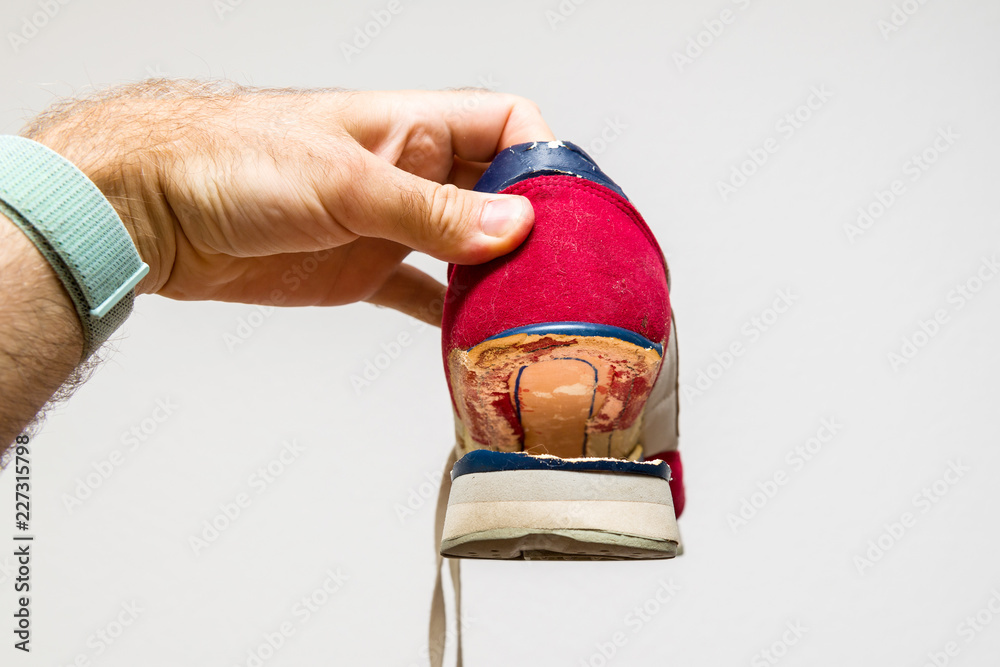 Male hang holding one sport footwear sneaker with broken sole - quality ...