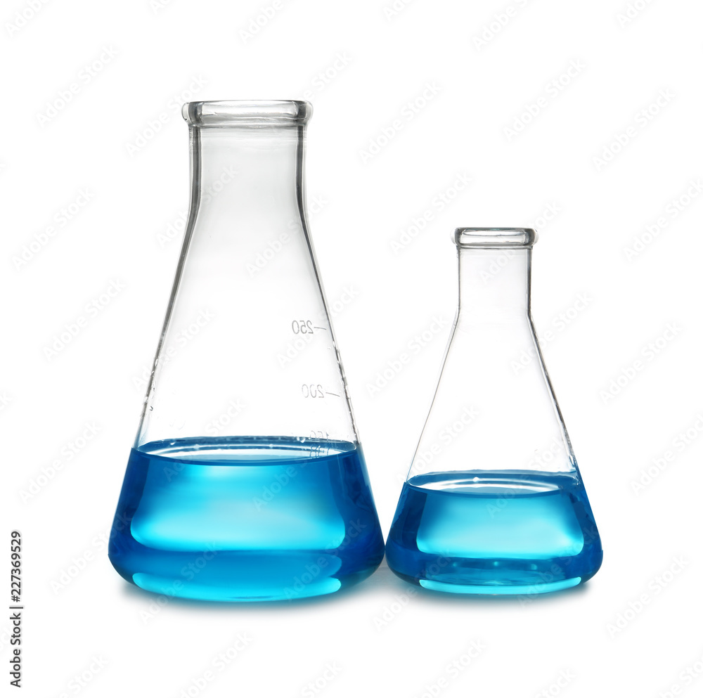 Conical flasks with liquid on table against white background ...