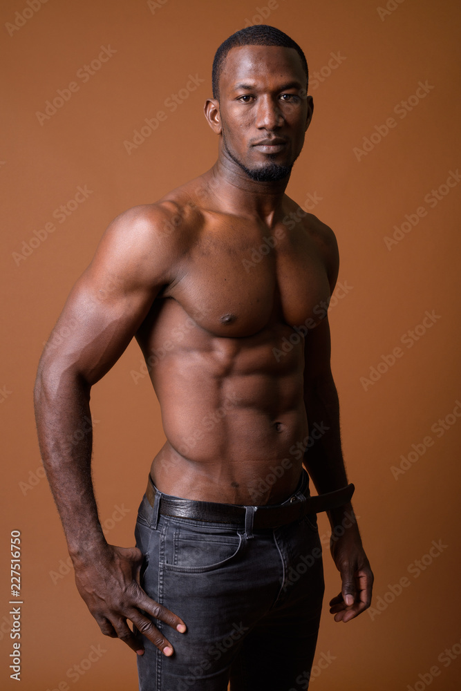 Handsome muscular African man shirtless against brown background Stock ...