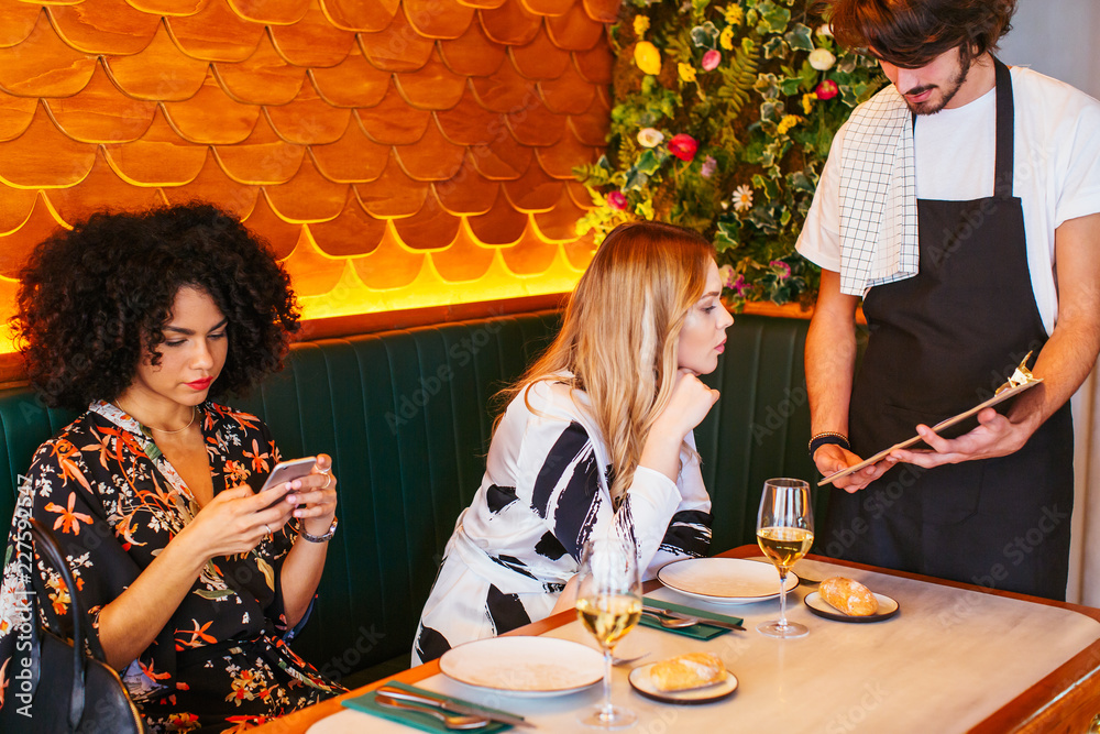 Waiter showing menu to customers. Stock Photo | Adobe Stock
