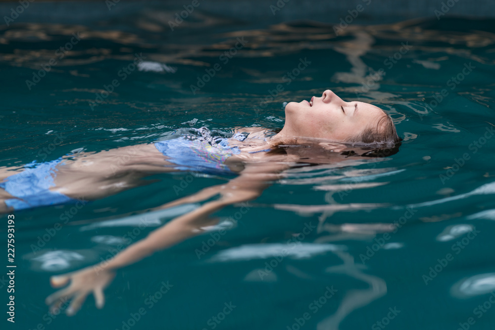 tween floating in pool Stock Photo | Adobe Stock