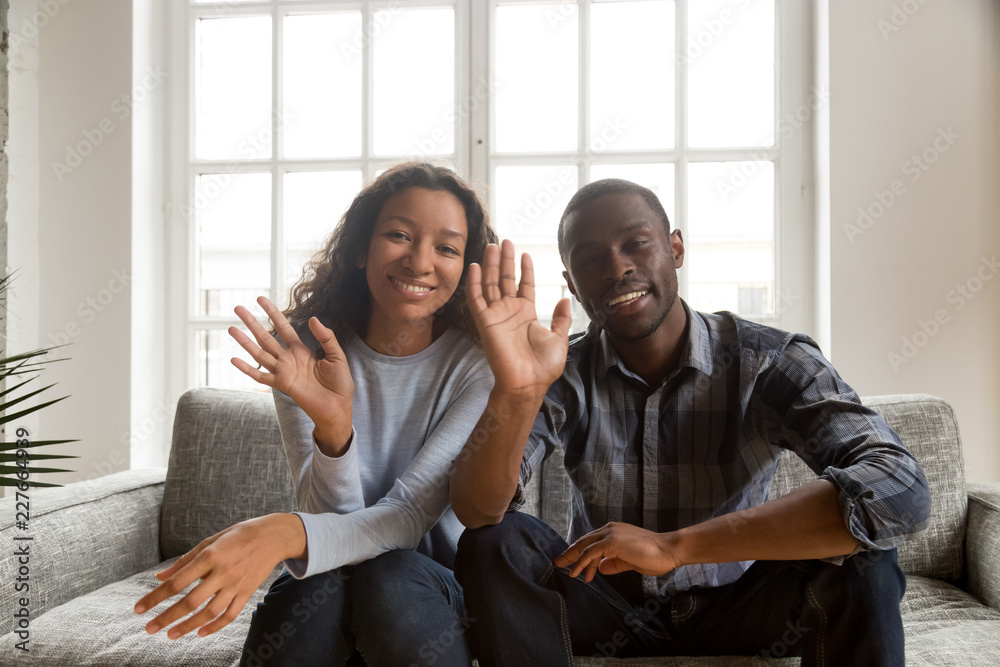 Black African cheerful married couple sitting on coach at home. Wife ...
