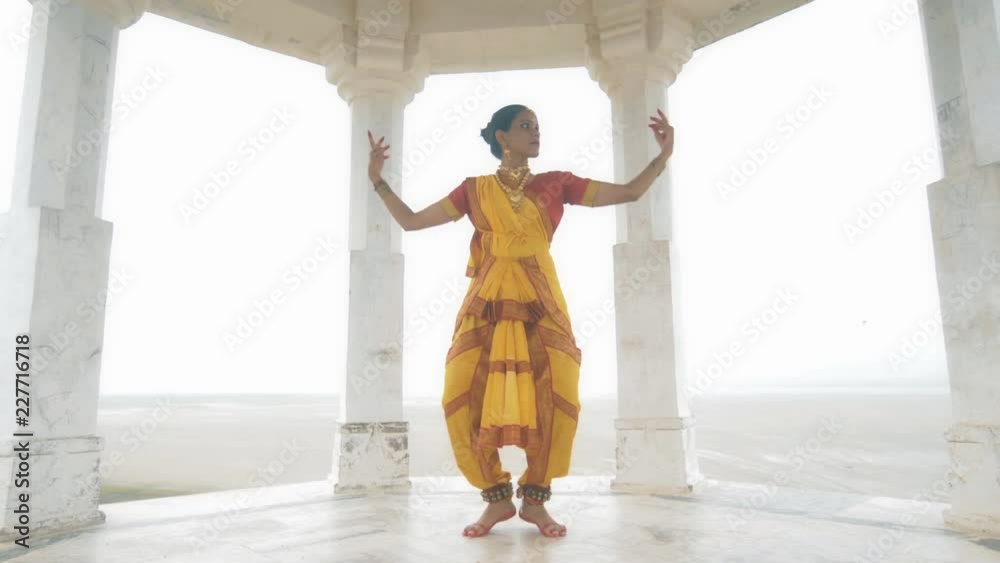 A wide shot of a Indian folk dancer dancing elegantly in a white marble ...