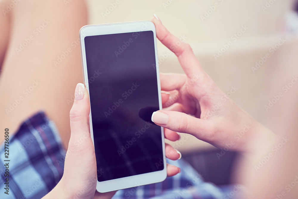 Back view of a woman hands using smart phone with blank screen close up ...