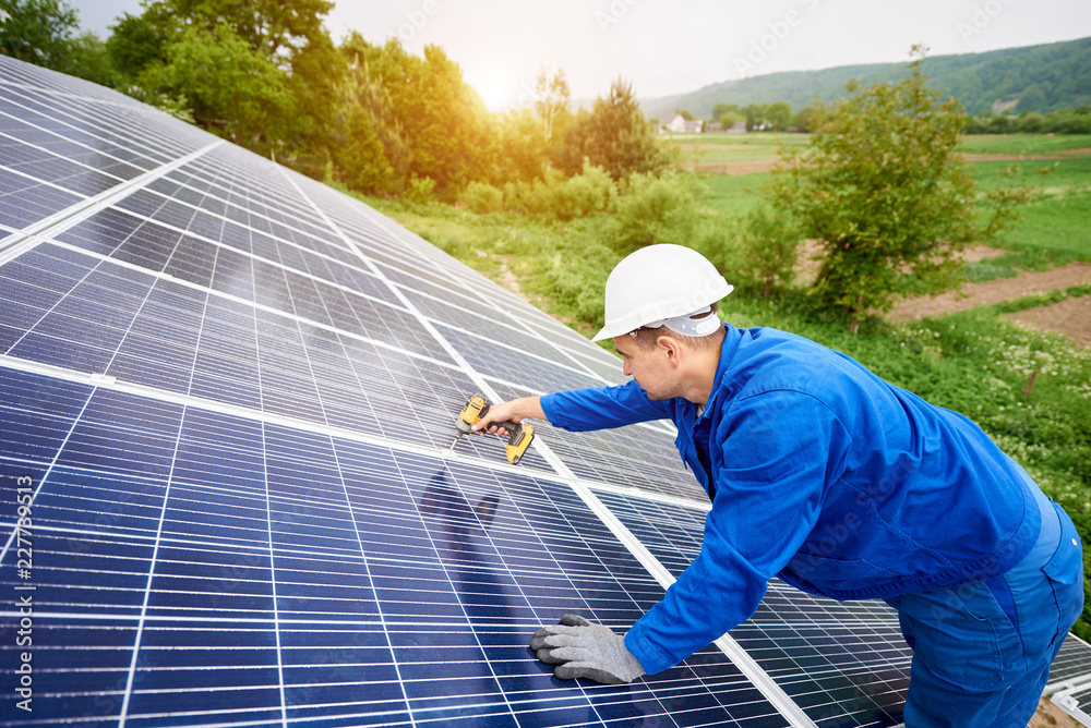Construction worker connects photo voltaic panel to solar system using ...