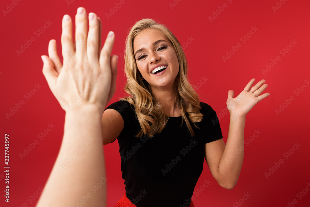 Excited woman looking camera give a high five to someone's hand ...