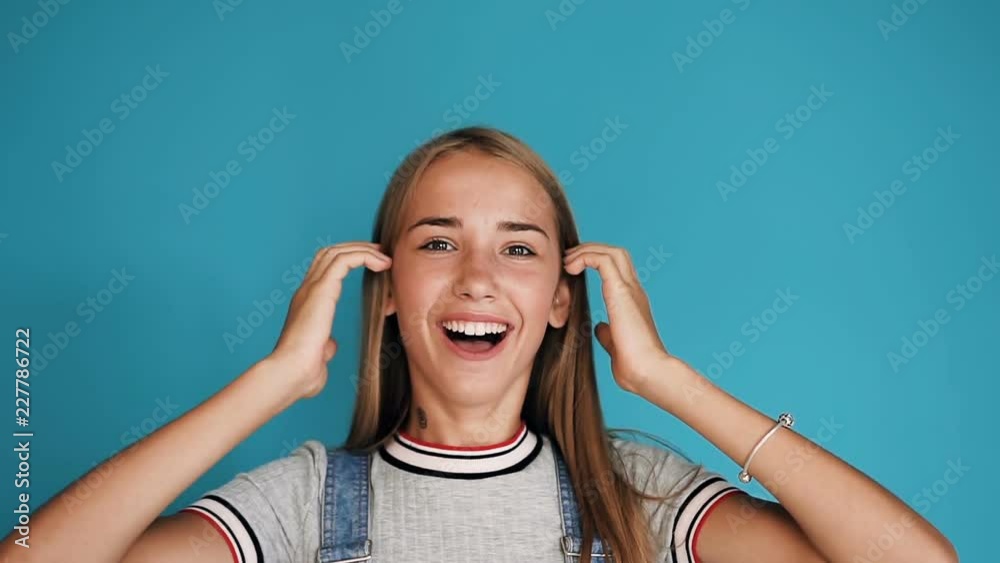 Video „Happy girl with long hair laughing and keeping hands at her face ...