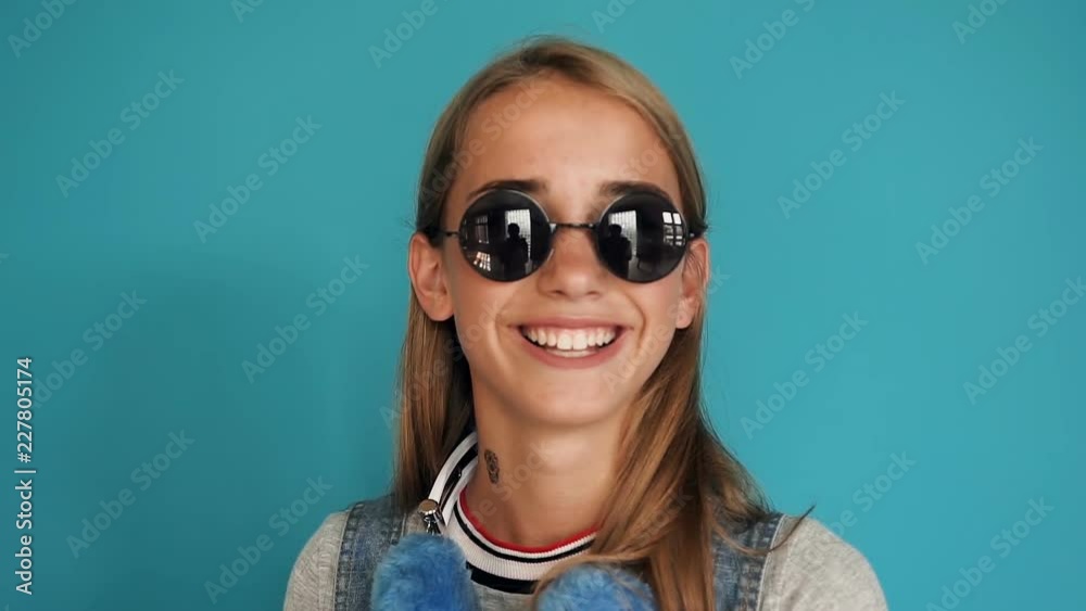 Teenage girl fashion model wearing modern sunglasses of round shape ...