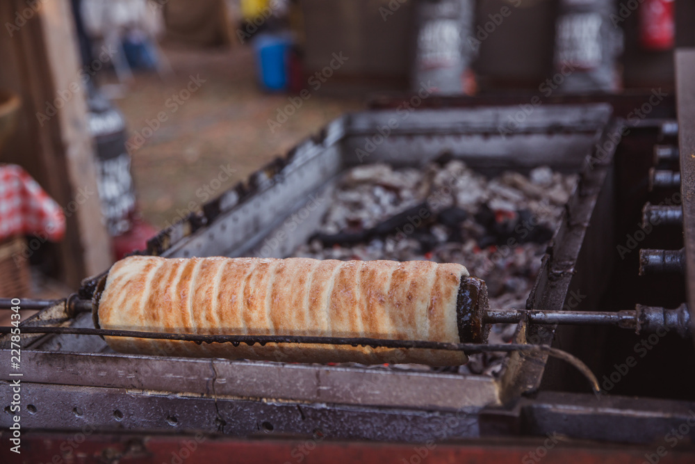 The baking of Kurtoskalacs, the traditional hungarian spit cake, in a ...