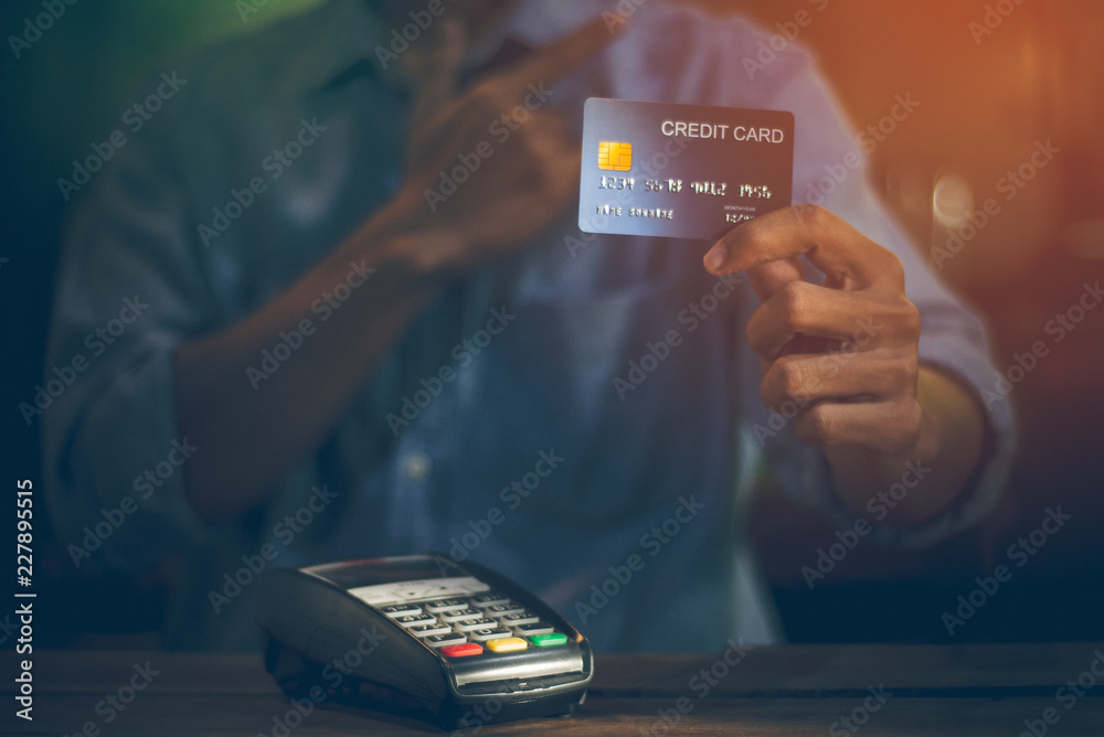 The hands of customers man is shown a credit card filed to the front ...