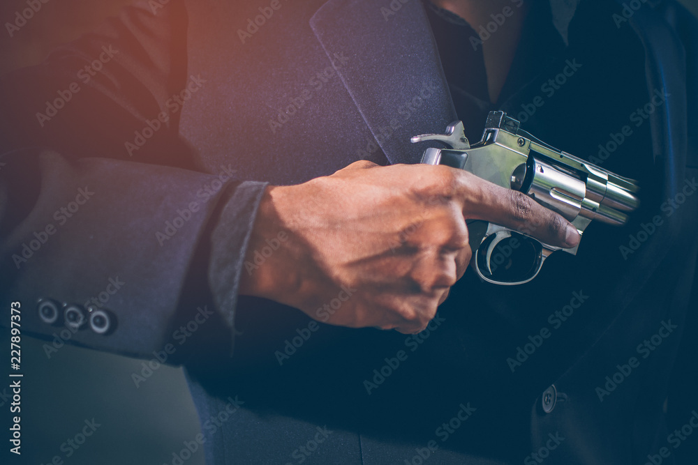 A close-up of a hand, the young man, wearing a black suit, pulling a ...