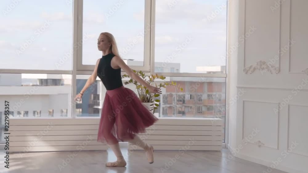 professional ballet dancer jumping into the splits against the backdrop ...