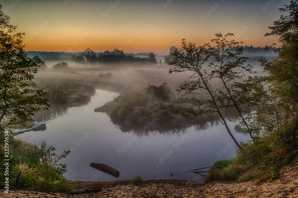Rzeka Grabia w centralnej Polsce zaraz po wschodzie słońca otulona ...