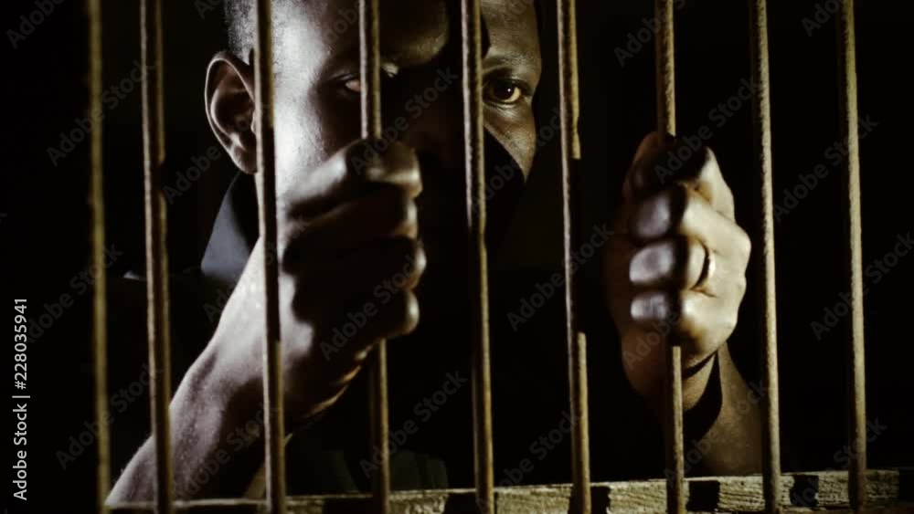 serious black man in prison, behind bars. Justice, prison, crime Stock ...