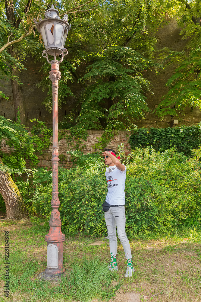 Extravagant (hipster) male model in nature. The guy poses in front of ...