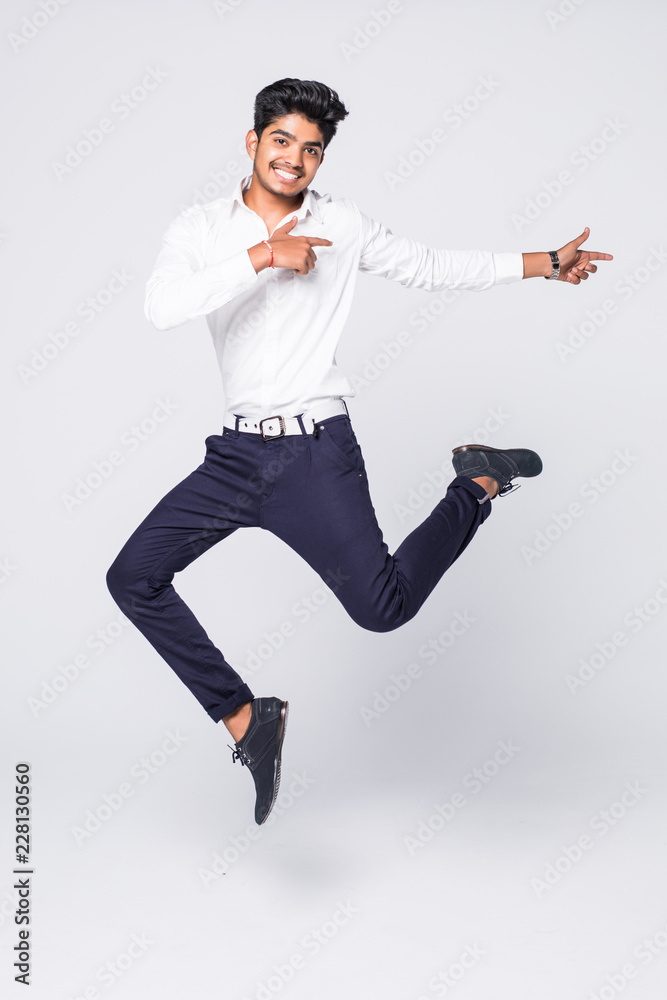 Full length of young indian man cheering and jumping isolated over ...