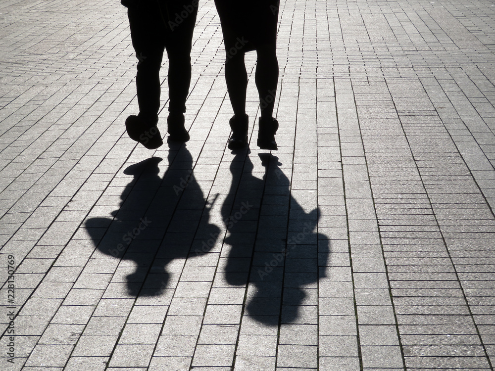 Two People Walking Down The Street