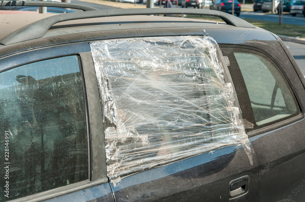 Broken and damaged shattered glass of the car side window protected ...