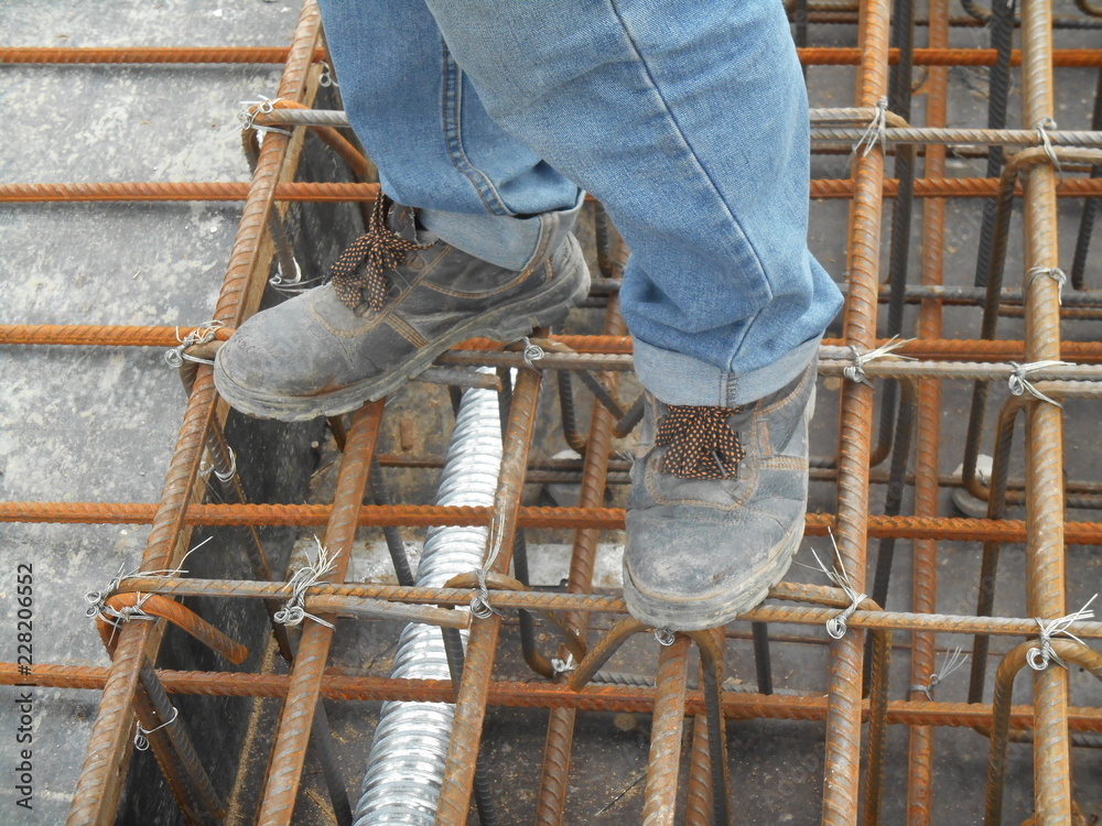 Construction workers wearing safety shoes standing on the under ...