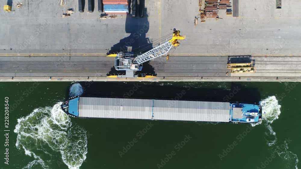 Aerial top down view of barge docking at harbor using manoeuvring ...