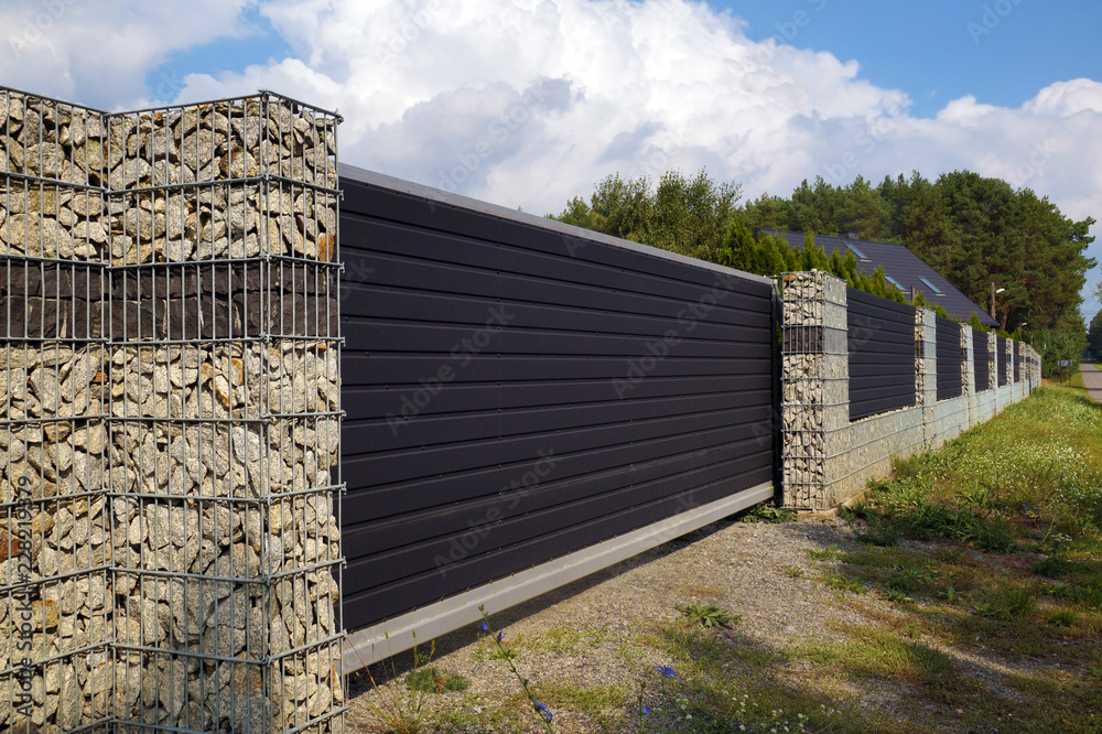 Wall. The entrance gate and a very long fence of the house using ...