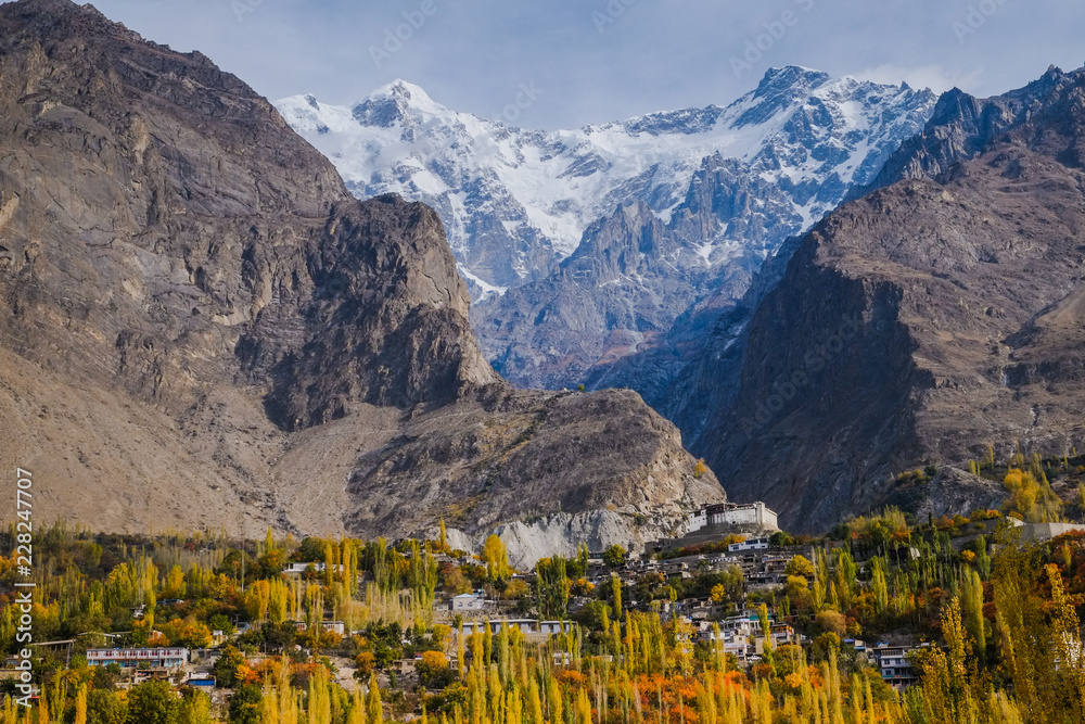 Autumn scene in Hunza valley with a view of Baltit fort and snow capped ...